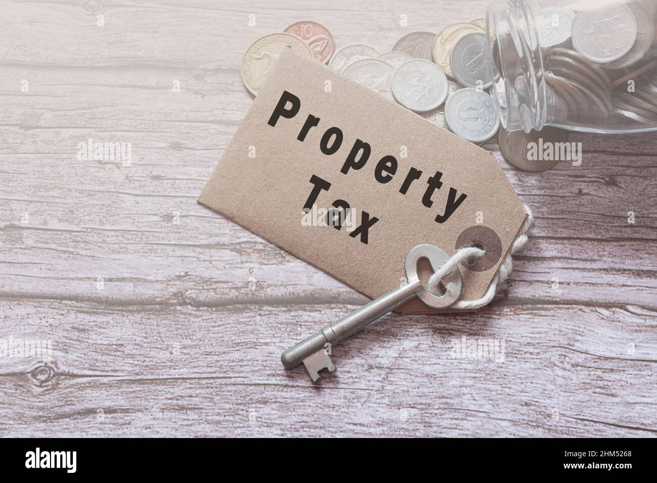 Property tax text on brown tag with a key and coins background on ...