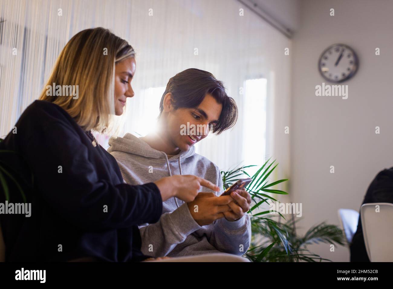 People sitting in waiting room and using phone Stock Photo - Alamy
