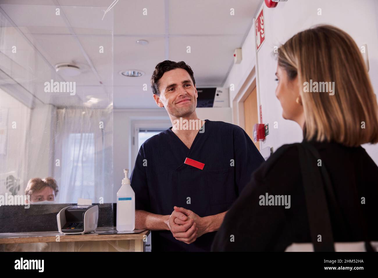 Patient and doctor at reception desk Stock Photo - Alamy