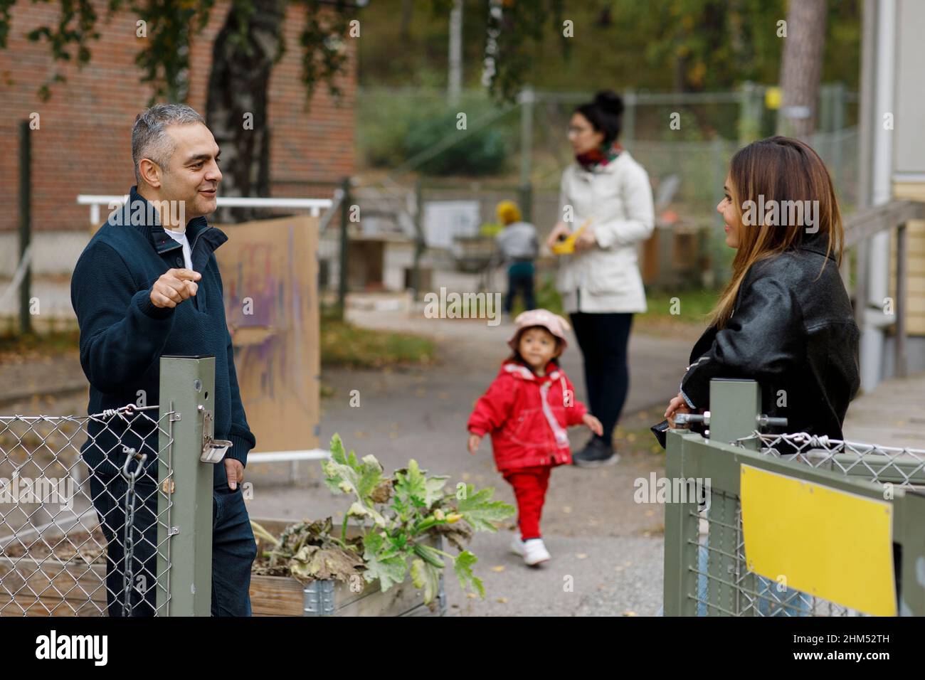 Man and woman talking at gate Stock Photo - Alamy