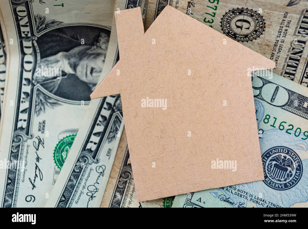 Brown paper house model with dollar banknotes on dark wooden table ...