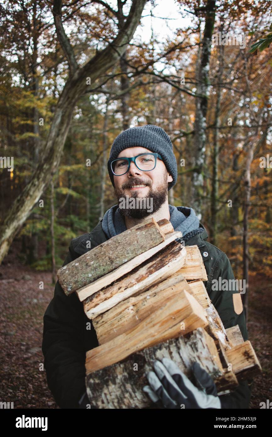Young man carrying firewood hi-res stock photography and images - Alamy