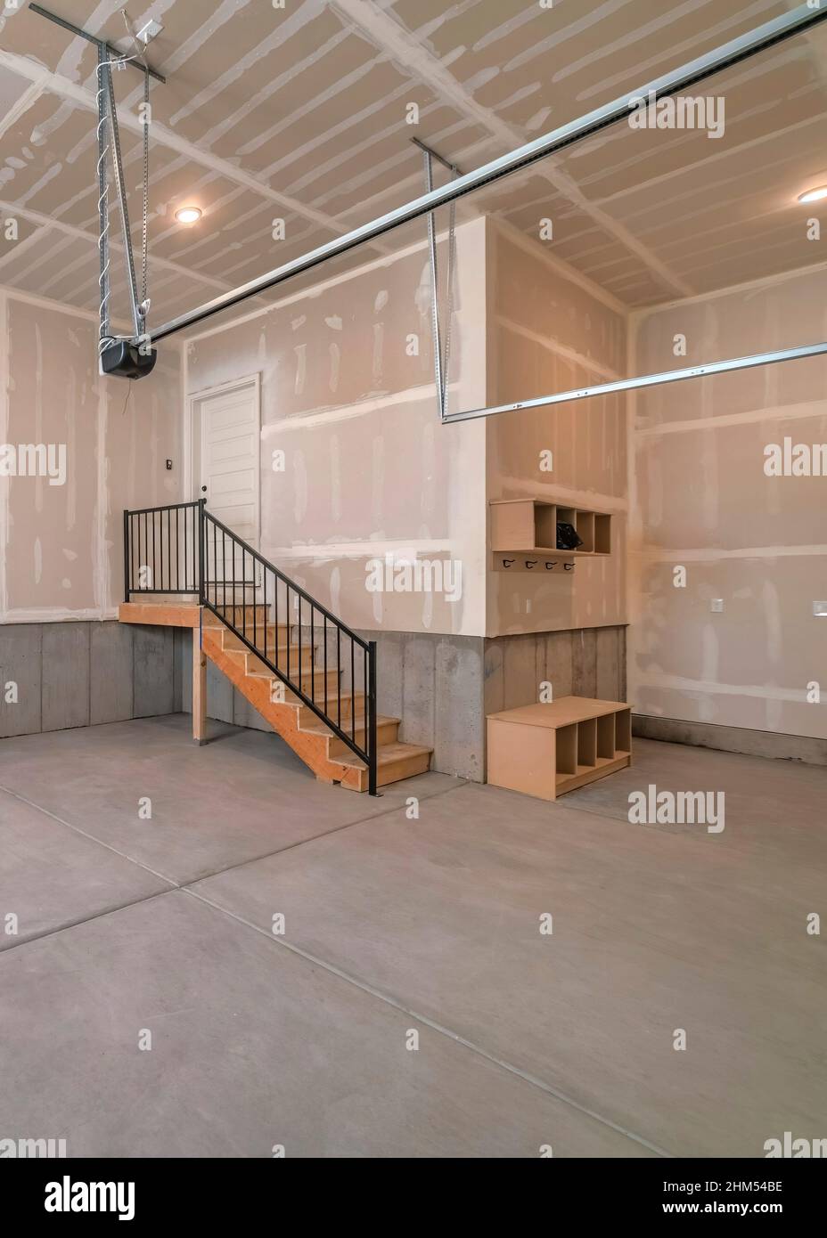 Vertical Interior of an unfinished garage with staircase leading to the ...