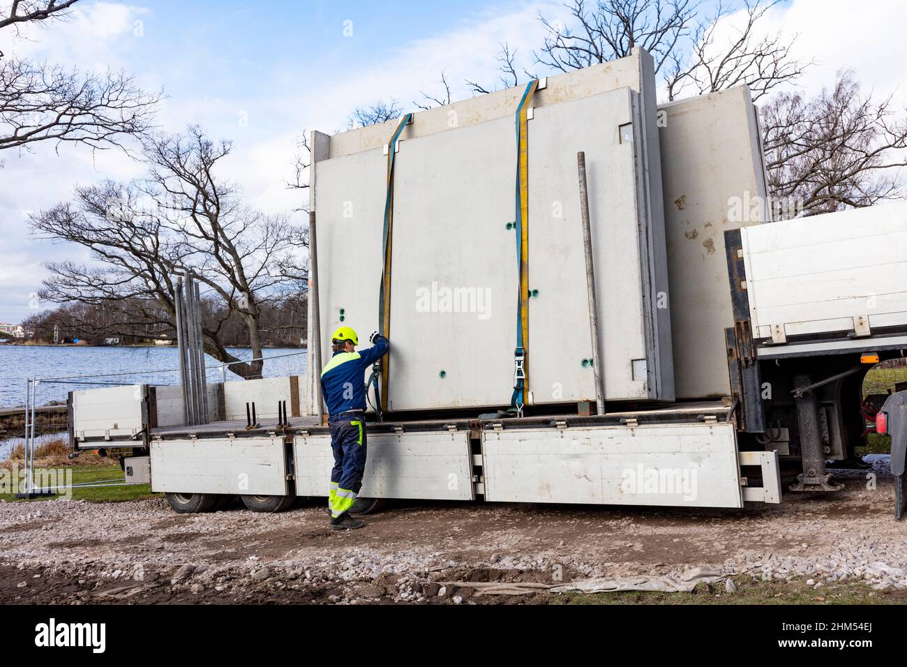 Worker strapping concrete slabs on truck Stock Photo - Alamy