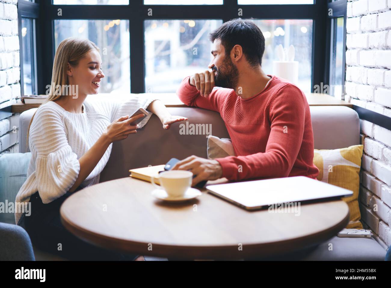 Happy young couple enjoying coffee break in coffeehouse in cozy cafe ...