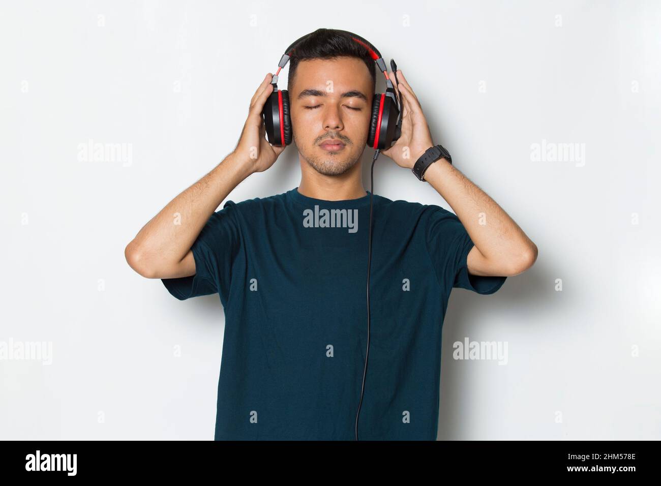 Happy young man listening music dancing and having fun on white ...
