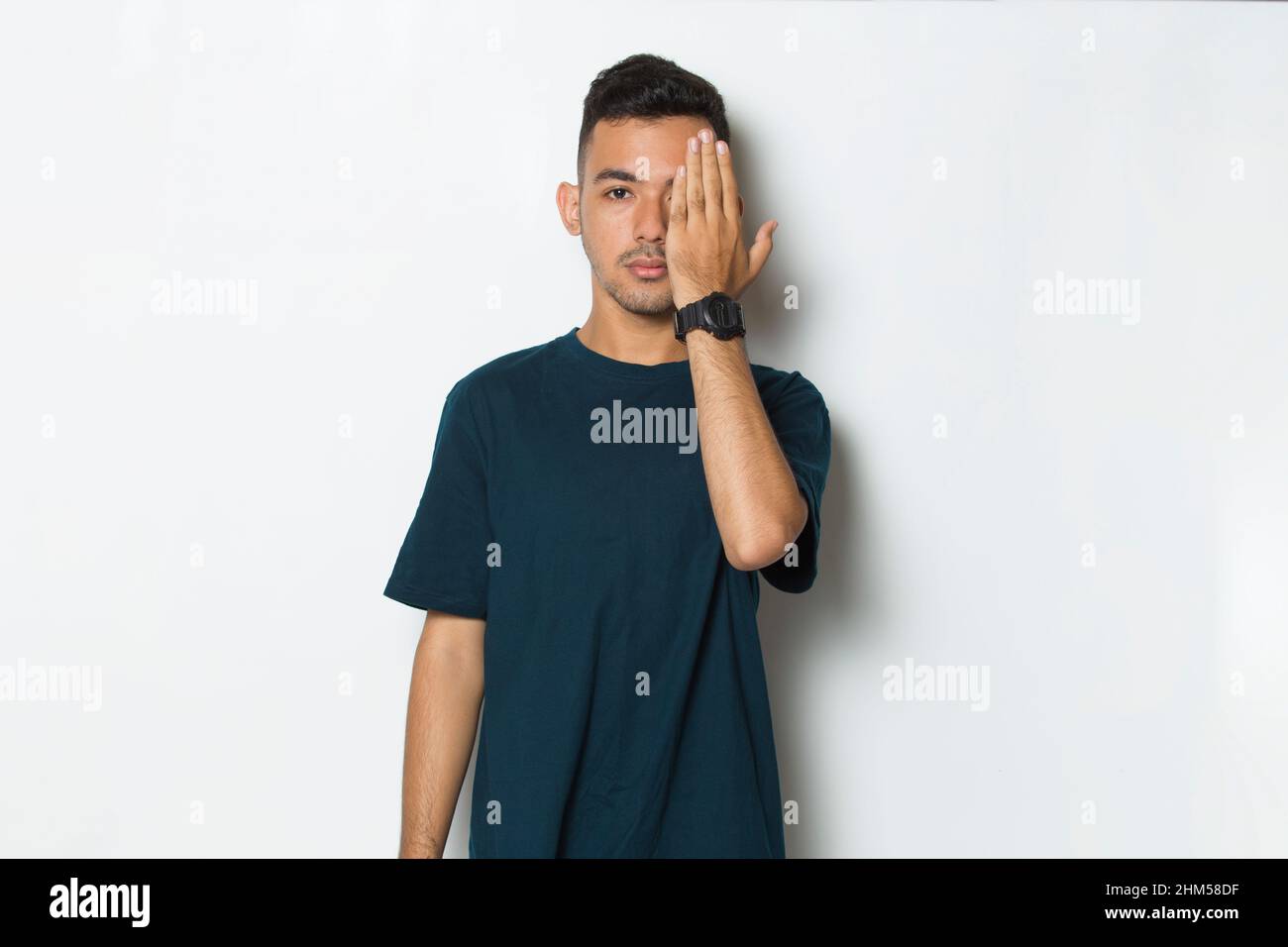 Young handsome man covering one eye with hand isolated on white ...