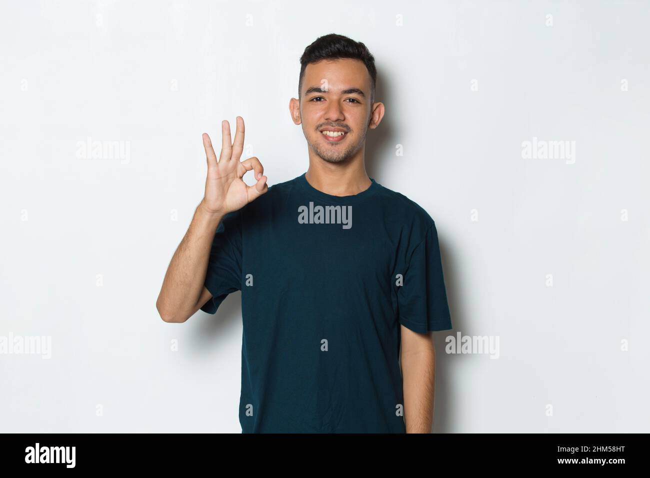 young handsome man with ok sign gesture tumb up isolated on white ...