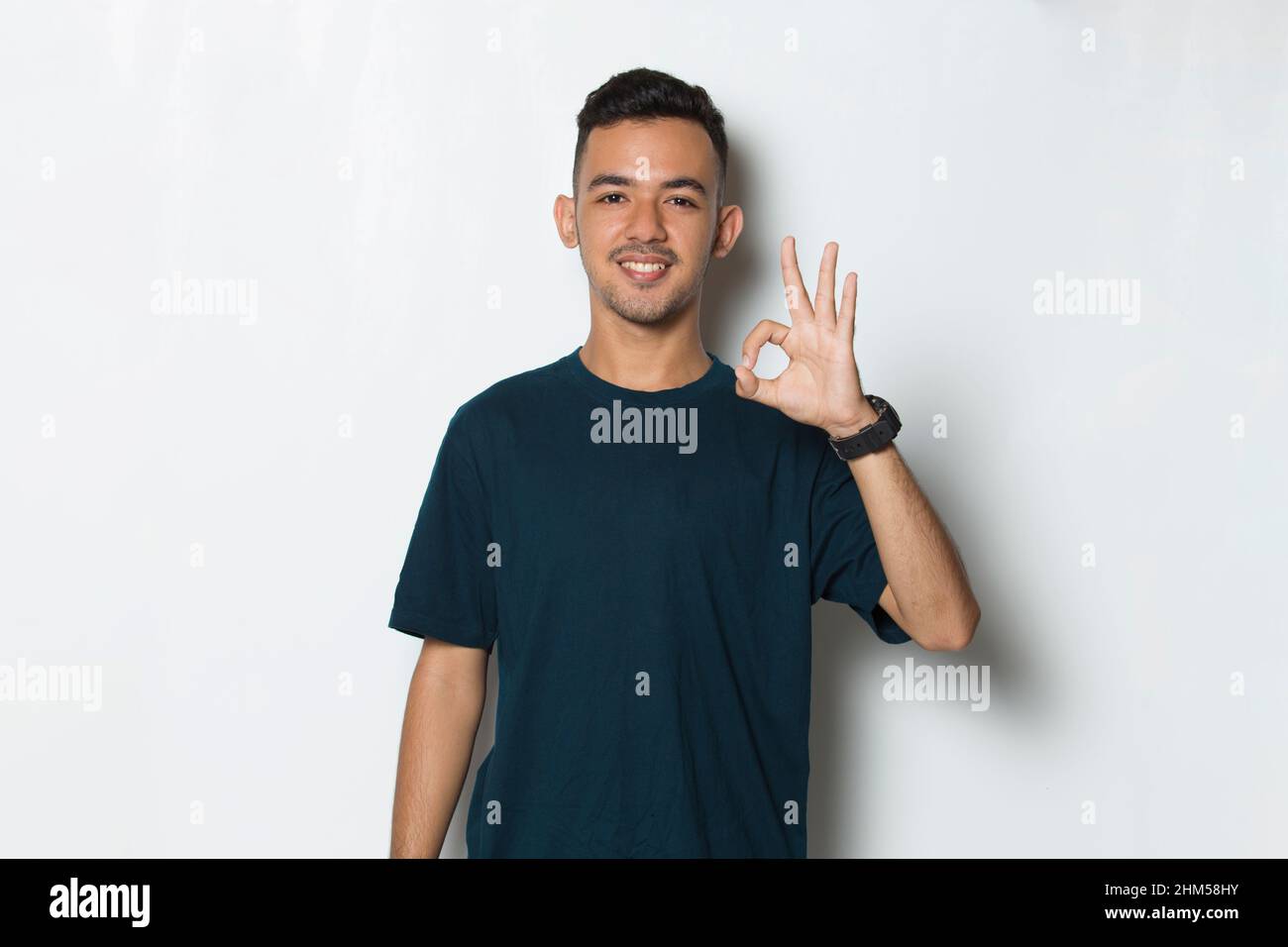young handsome man with ok sign gesture tumb up isolated on white ...