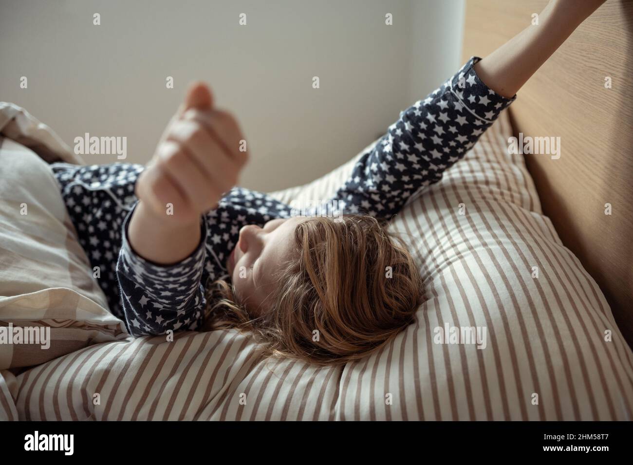 Cute teen child girl in pajamas lazy wake up in the morning stretching ...