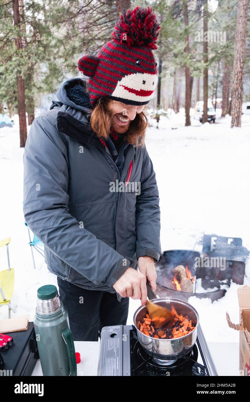 A man cooks beans and veggies while winter camping Stock Photo - Alamy