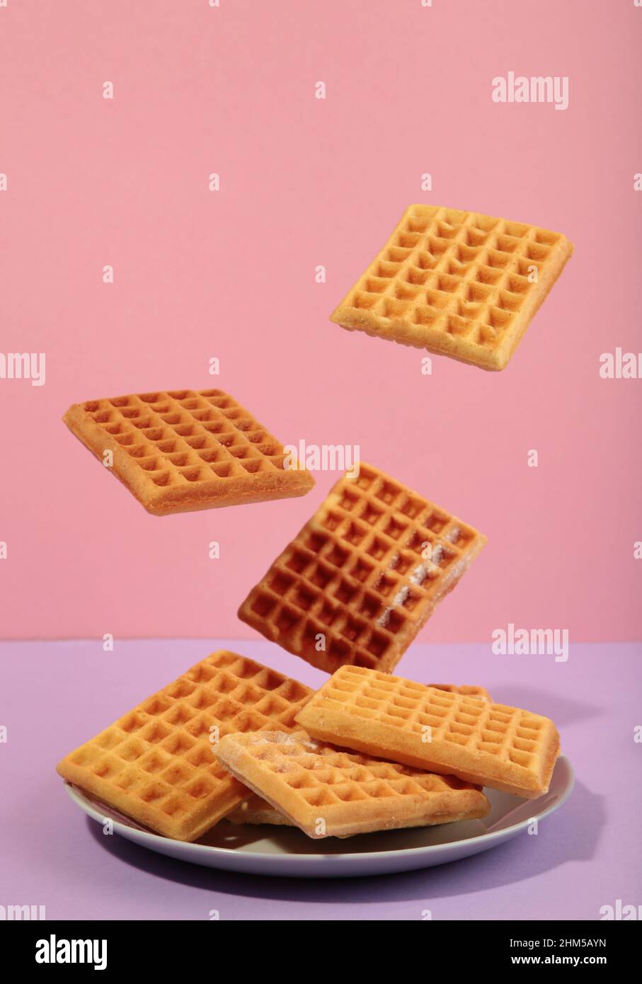 Belgian waffles flying in air on pink background Stock Photo - Alamy