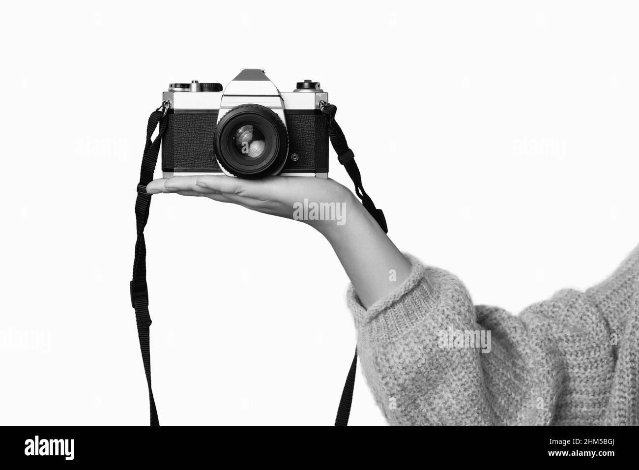 Black and white studio photo of the palm of a hand presenting a camera ...