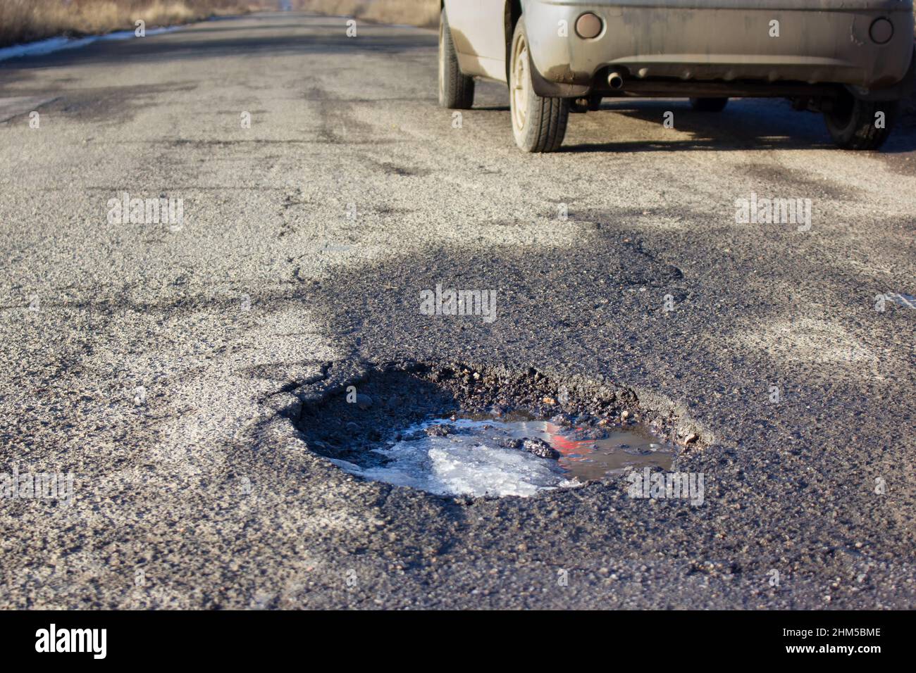 Pit on the asphalt. The car in the background Stock Photo - Alamy