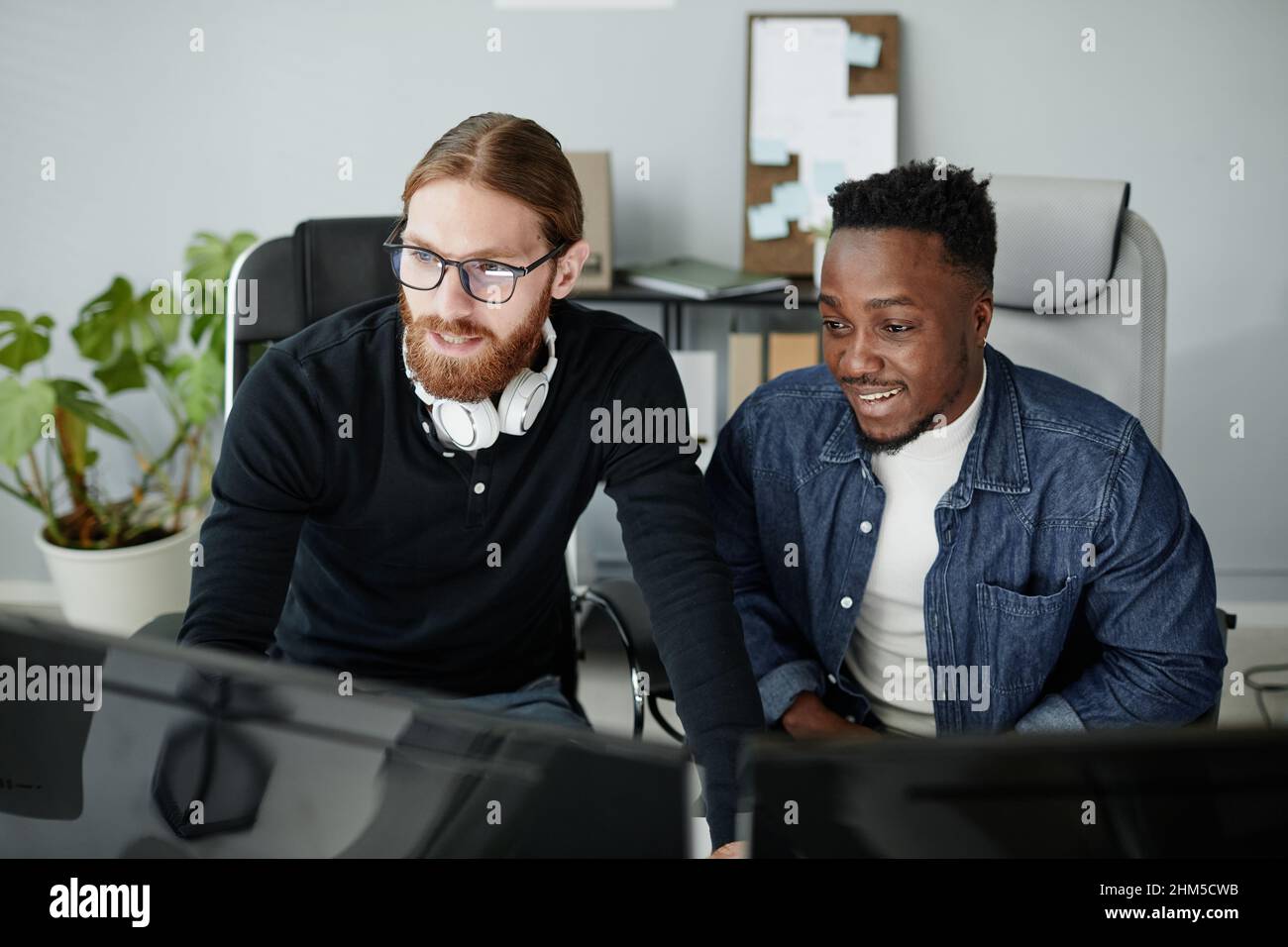 Small group of happy young intercultural diversity programmers in ... Small group of happy young intercultural diversity programmers in ...