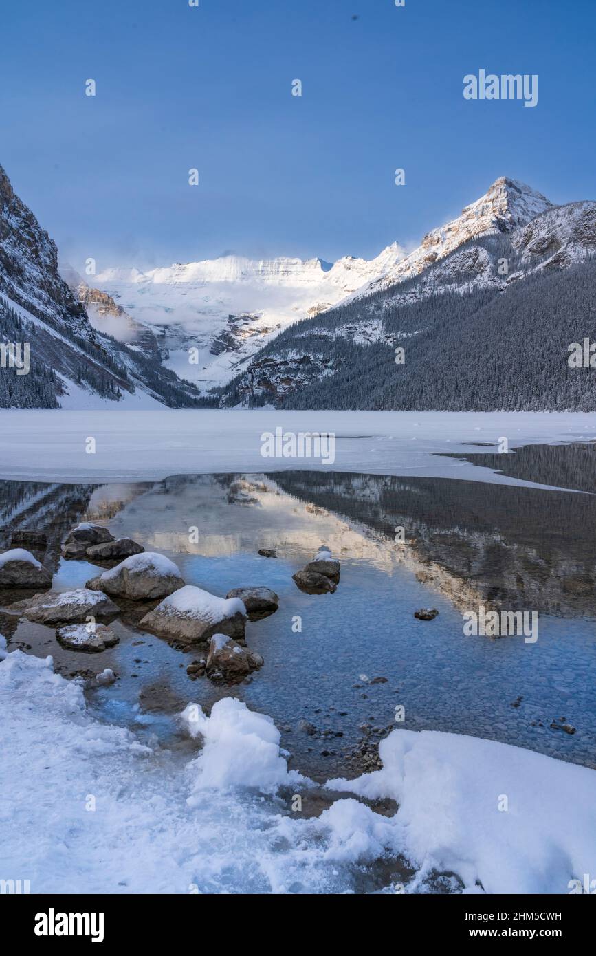 A view of a partially frozen Lake Louise in winter, Banff National Park ...