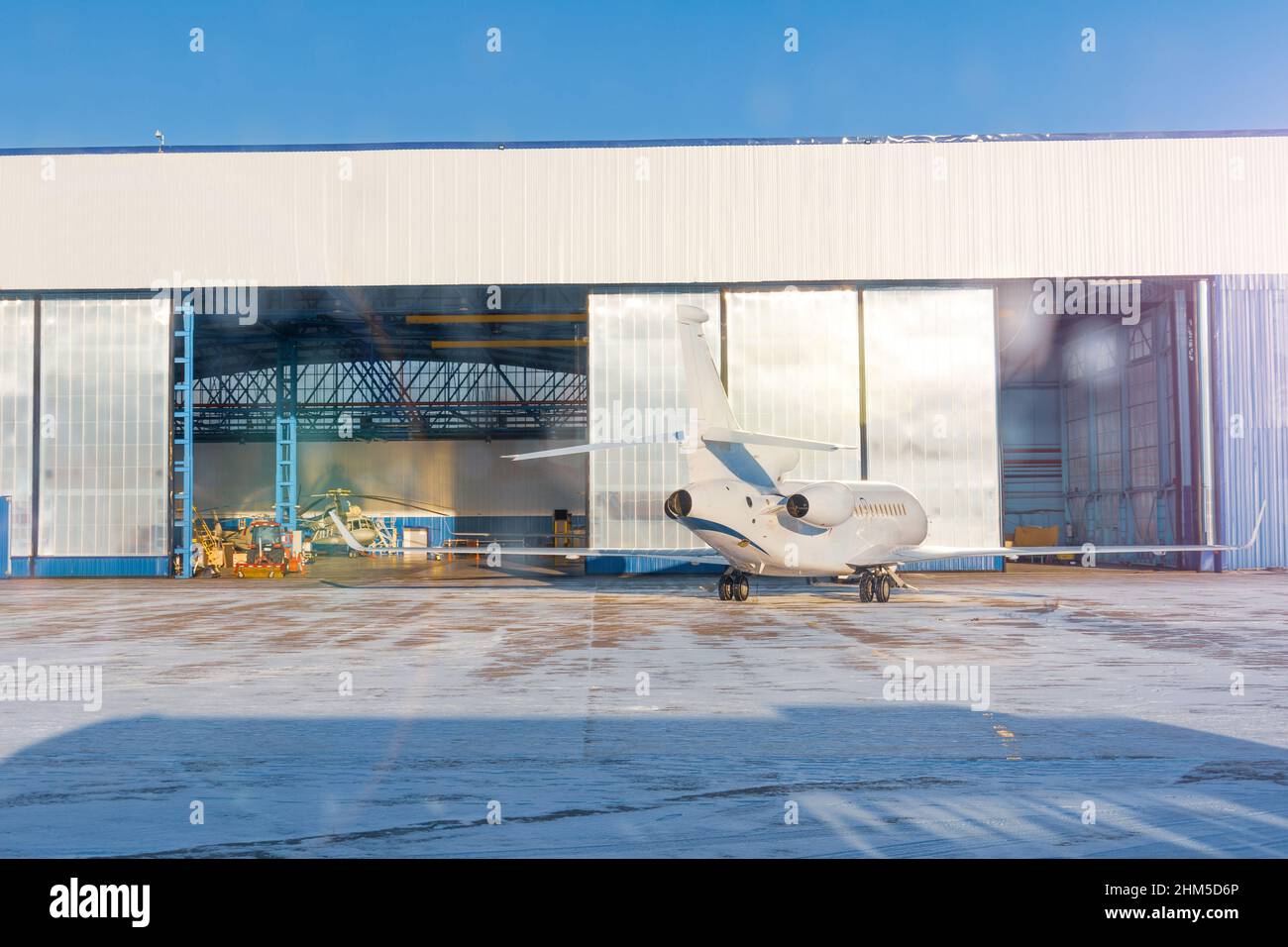 Gate open hangar and outside a small jet ready to roll in Stock Photo ...