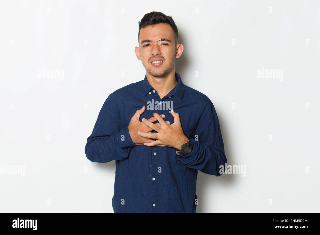 Young handsome man having heart attack isolated on white background ...