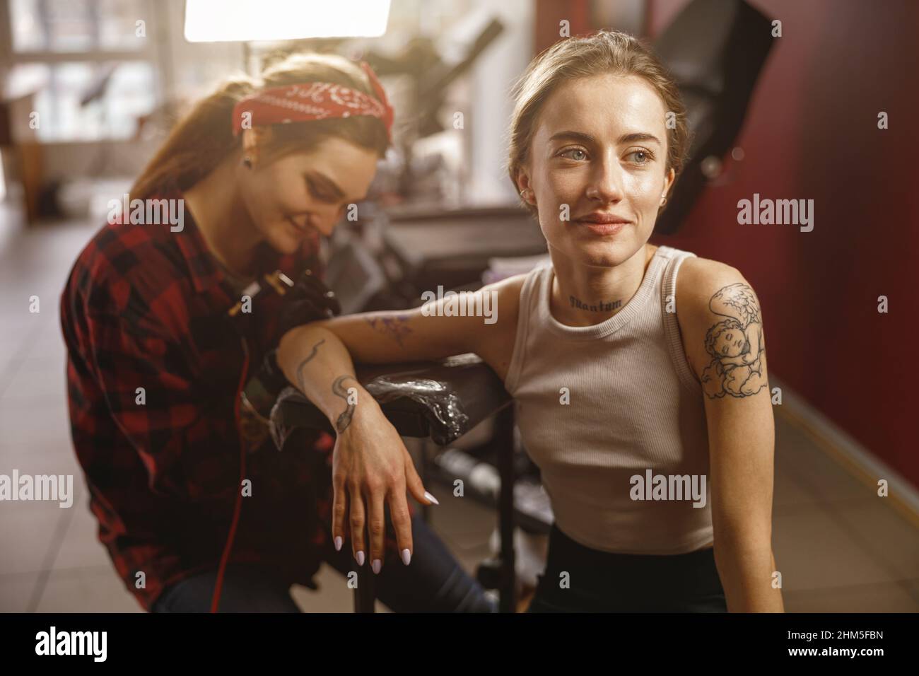 Female customer waiting while tattoo master drawing tattoo Stock Photo ...