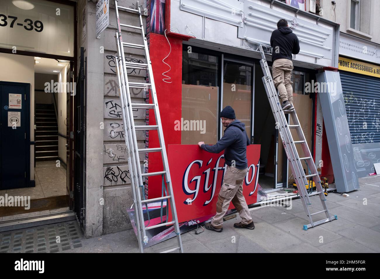 Workers dismantle signage from a London souvenir shop which was having ...