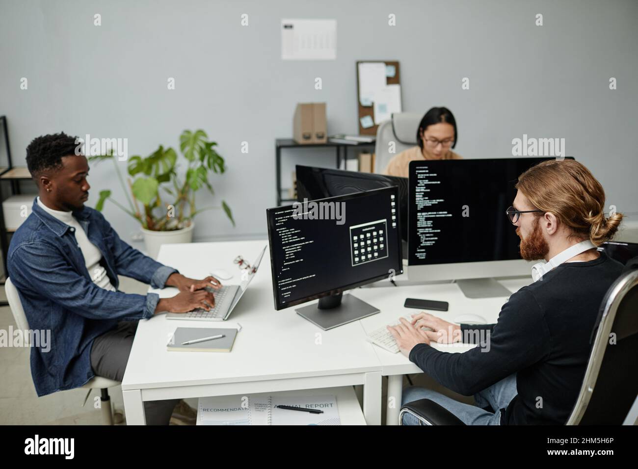 Group of young intercultural software engineers working over new ...