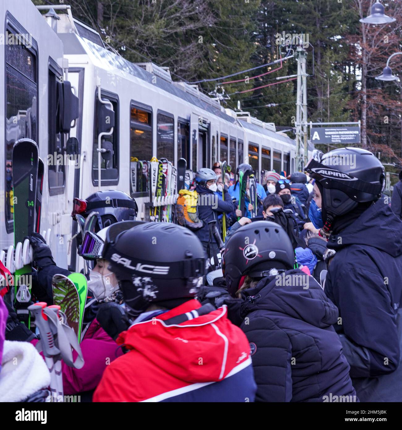 Numerous ski vacationers wearing Corona masks are very crowded with ...