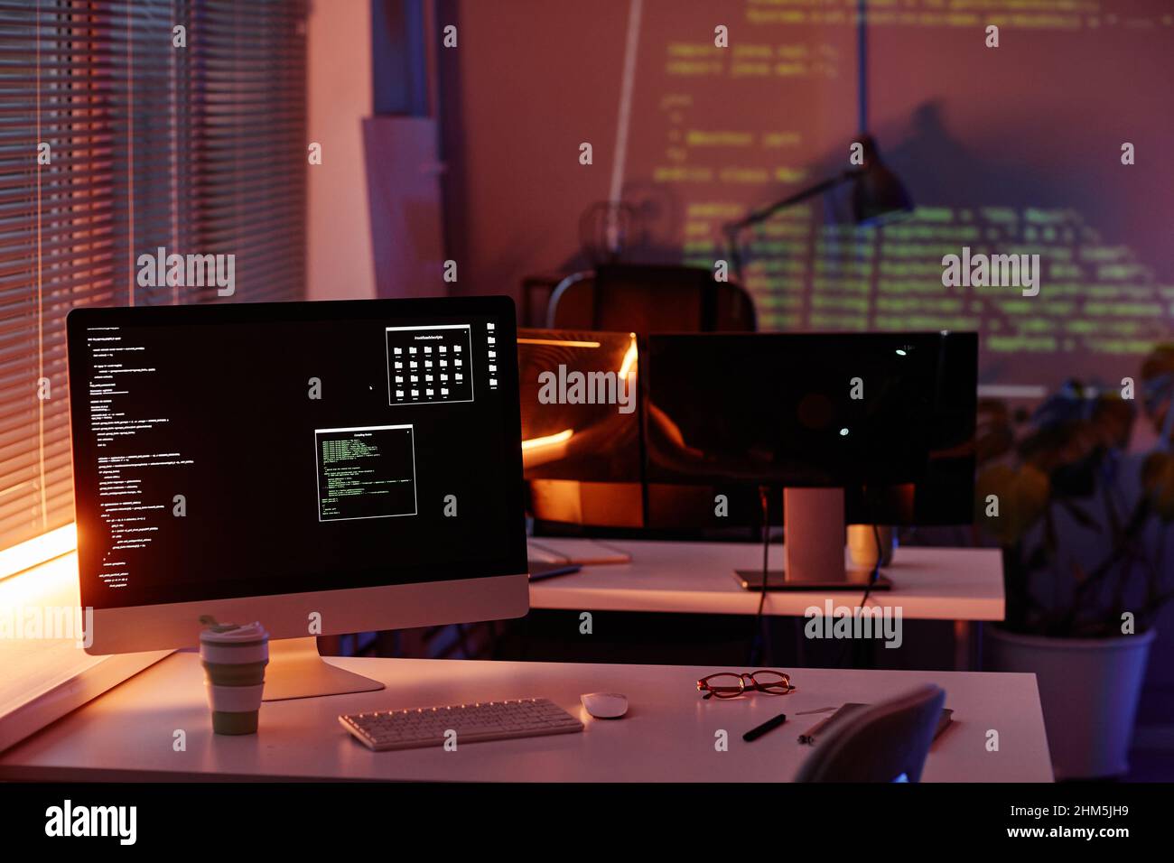 Computer monitor with coded data on screen standing on workplace of ...