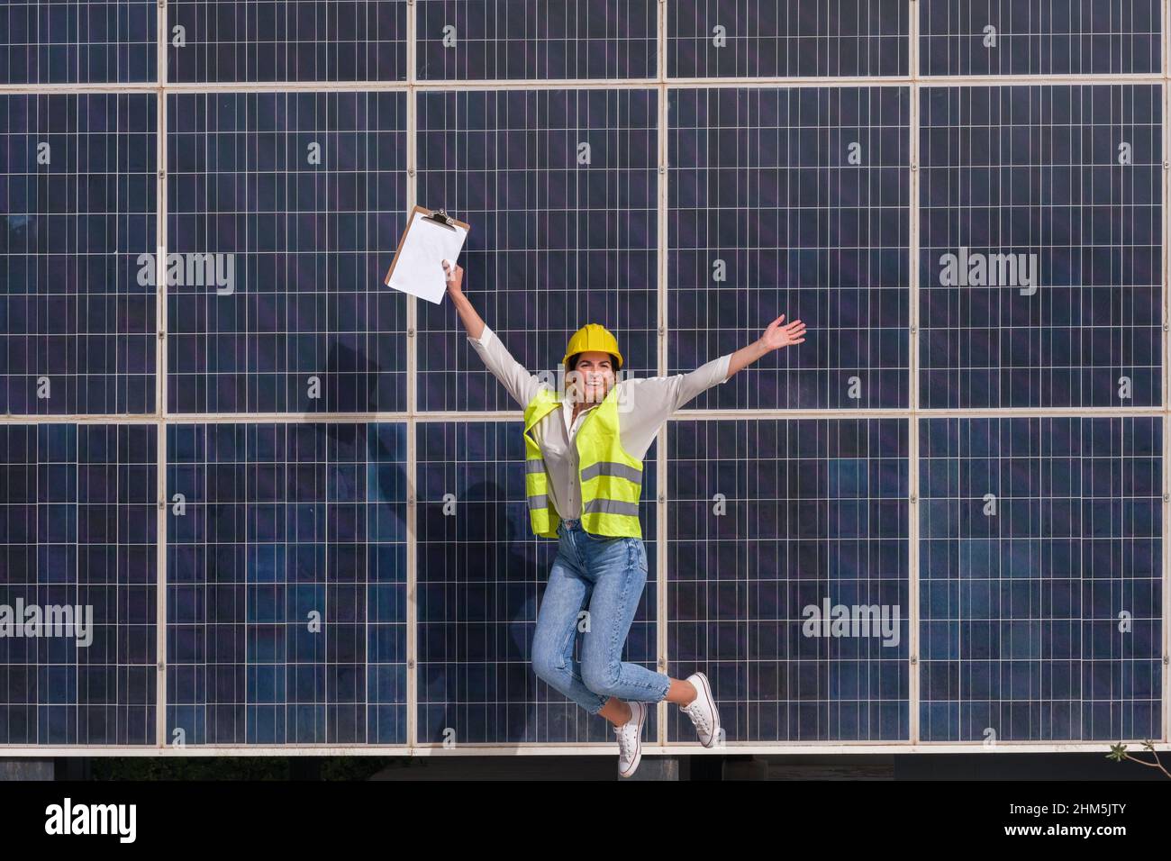 woman engineer jumping for joy next to solar panels Stock Photo - Alamy