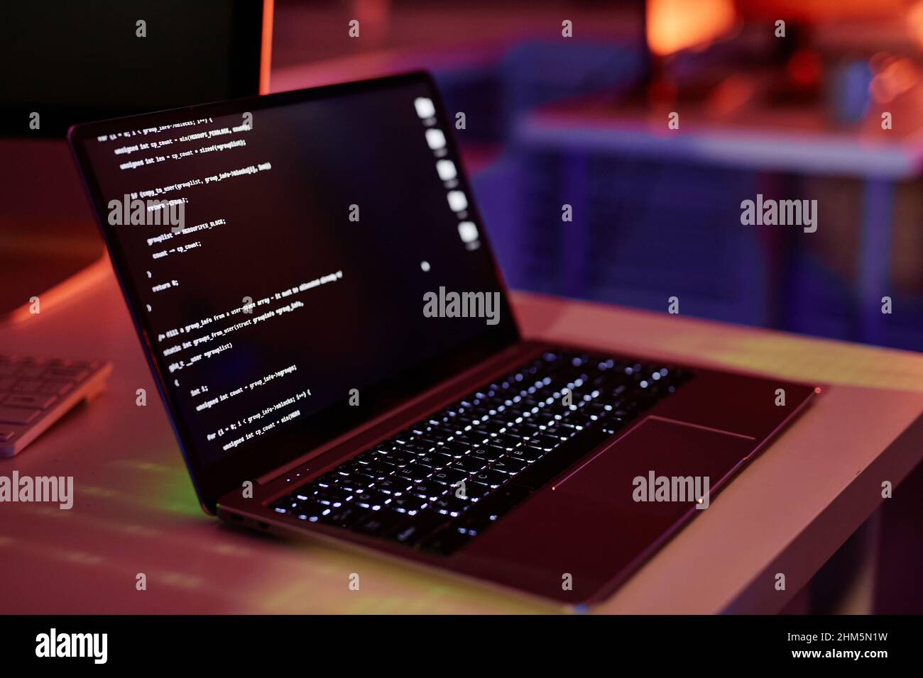 Laptop with coded data on screen standing on workplace of contemporary ...