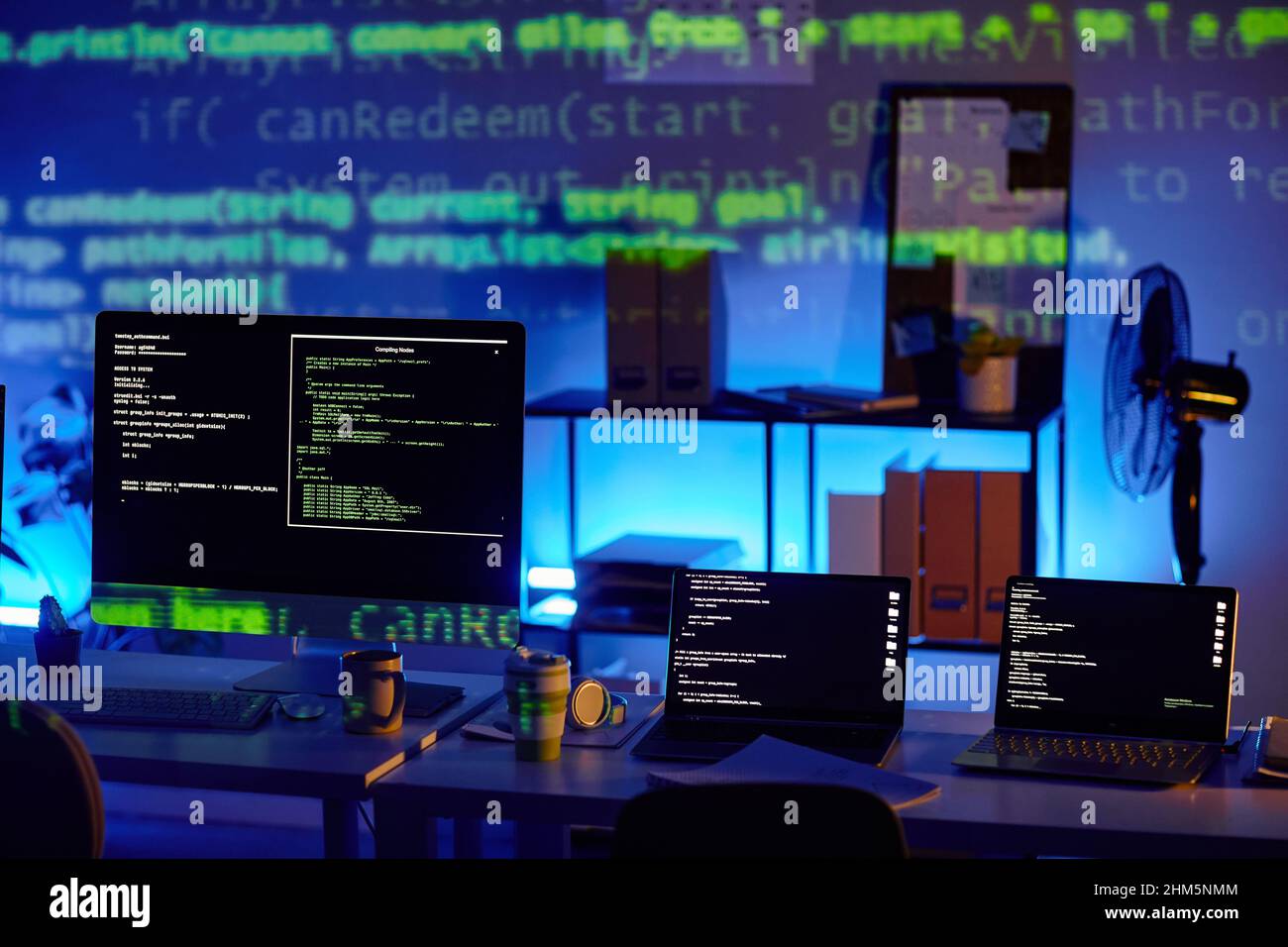 Row of laptops and computer monitor with decoded data on their screens ...