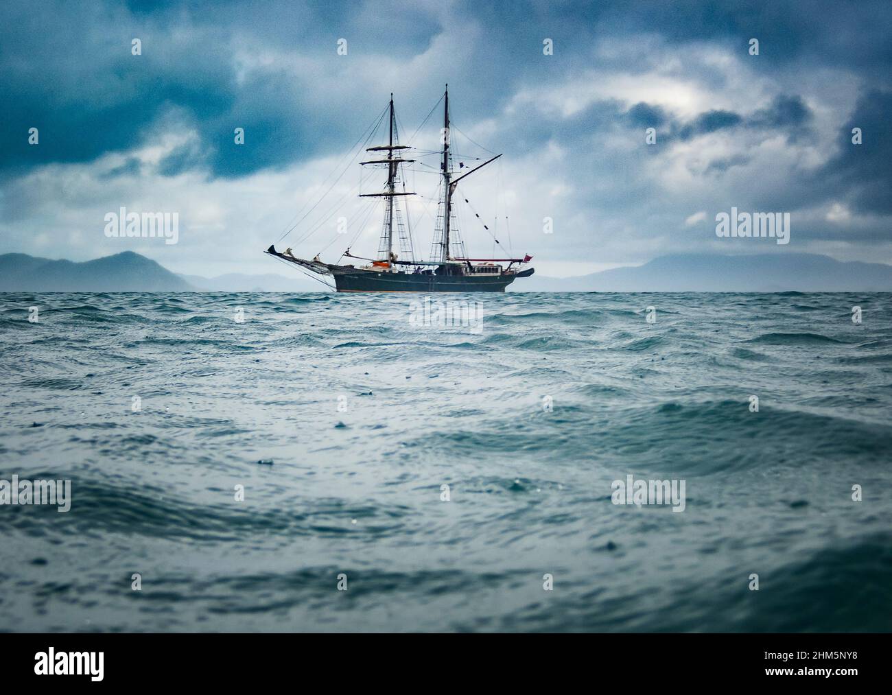 Traditional wooden sail boat in rough weather at dusk off the ...