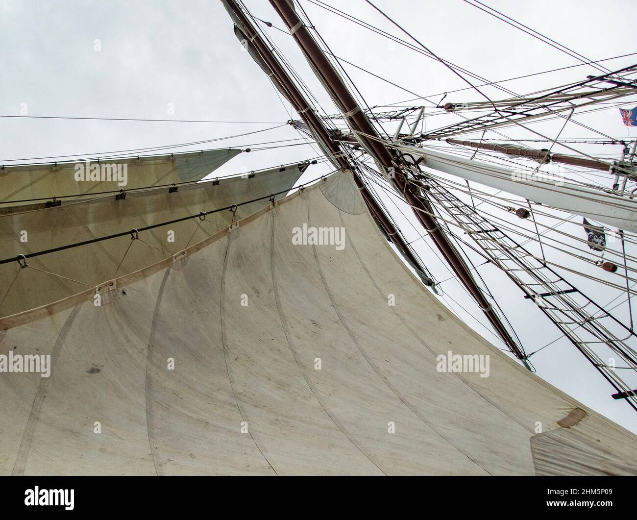 View of rigging and sail on a tall ship, looking up towards the sky ...