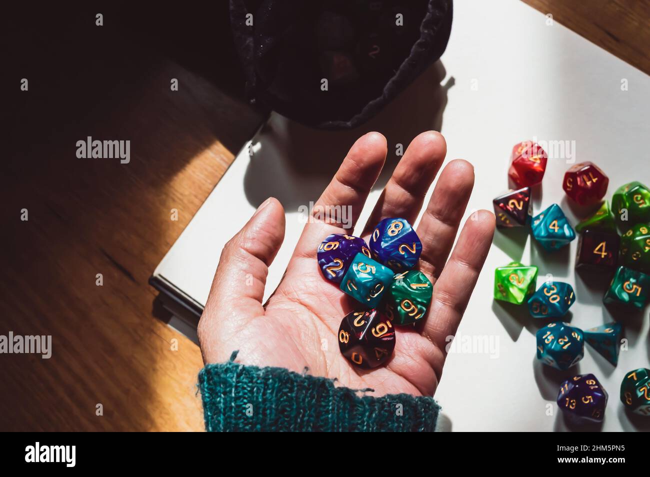 Image of a hand holding various colored and shaped role-playing dice ...
