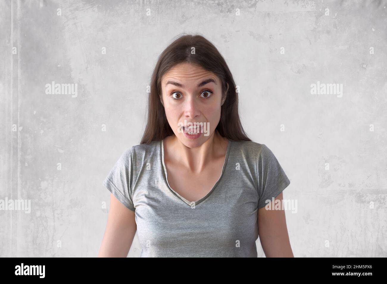 Angry woman loud and screaming on a white concrete background Stock ...