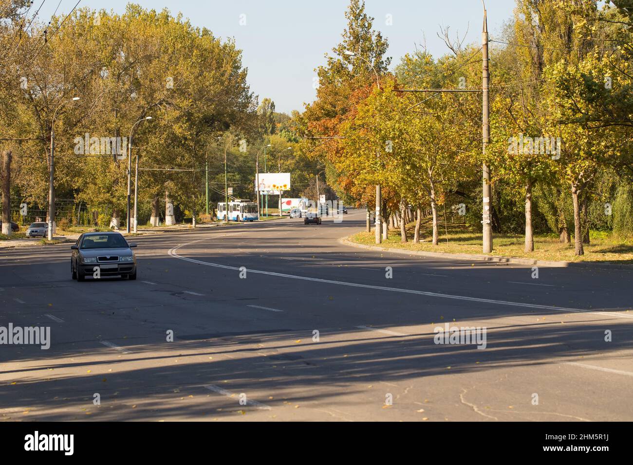 Cars and a trolley bus on a road curve in a post-Soviet city Stock ...