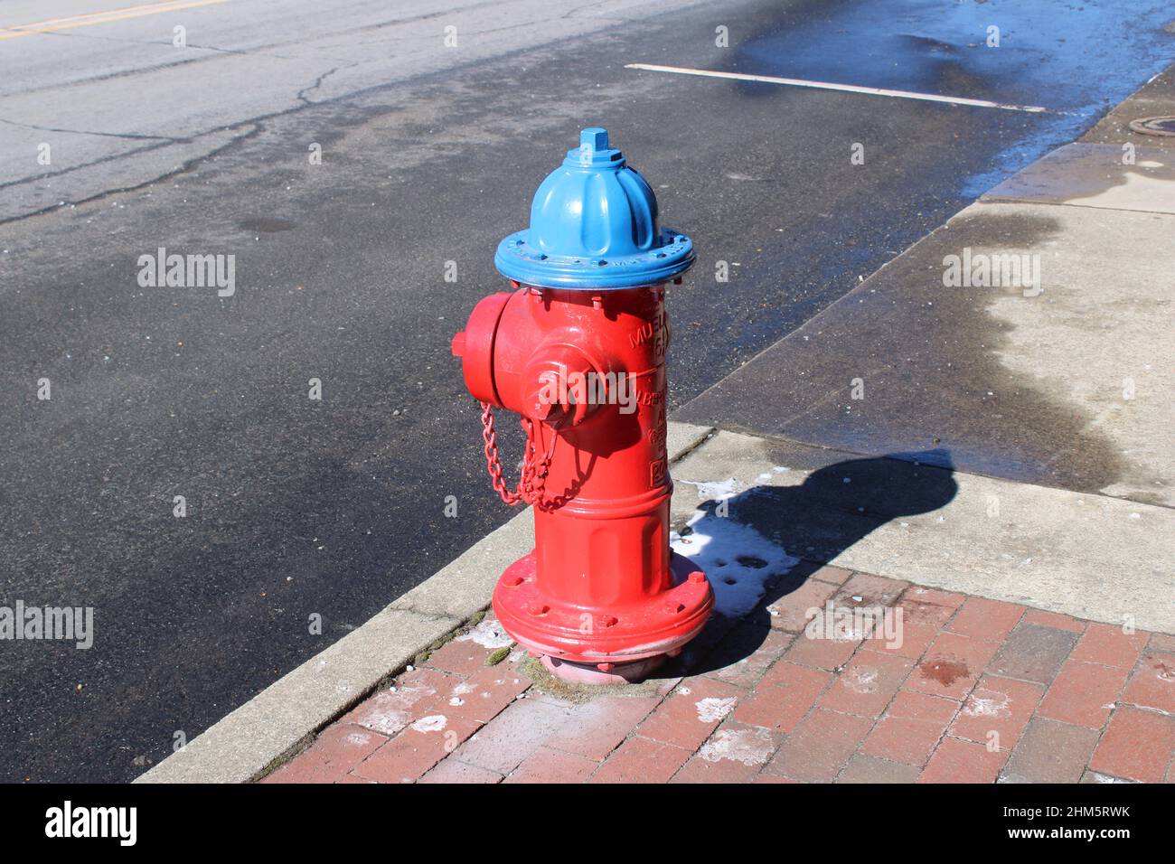 Red and blue fire hydrant on small town street Stock Photo - Alamy