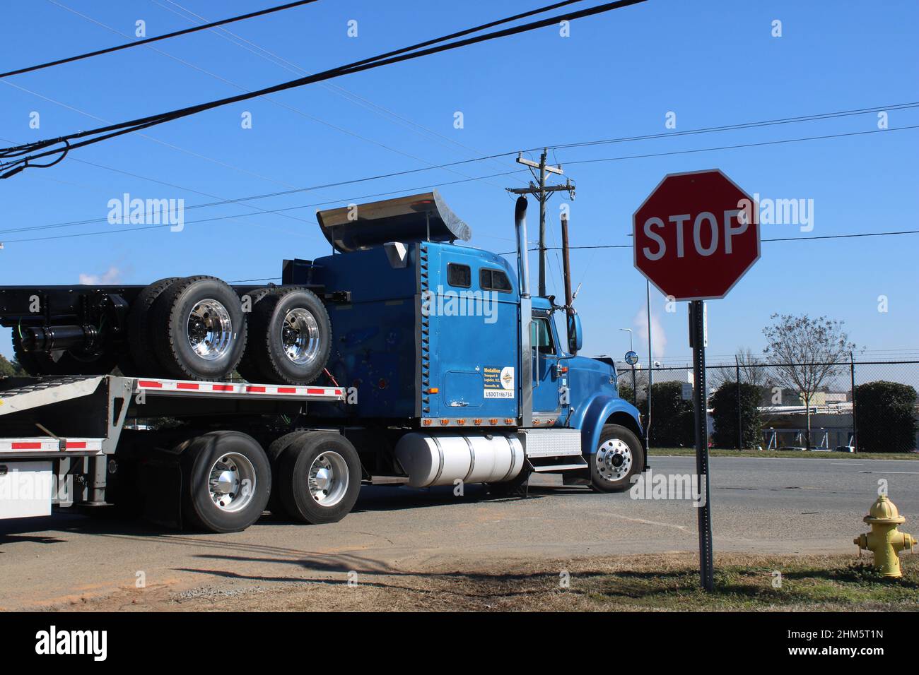 Blue tractor trailer waiting to turn right at stop sign Stock Photo - Alamy