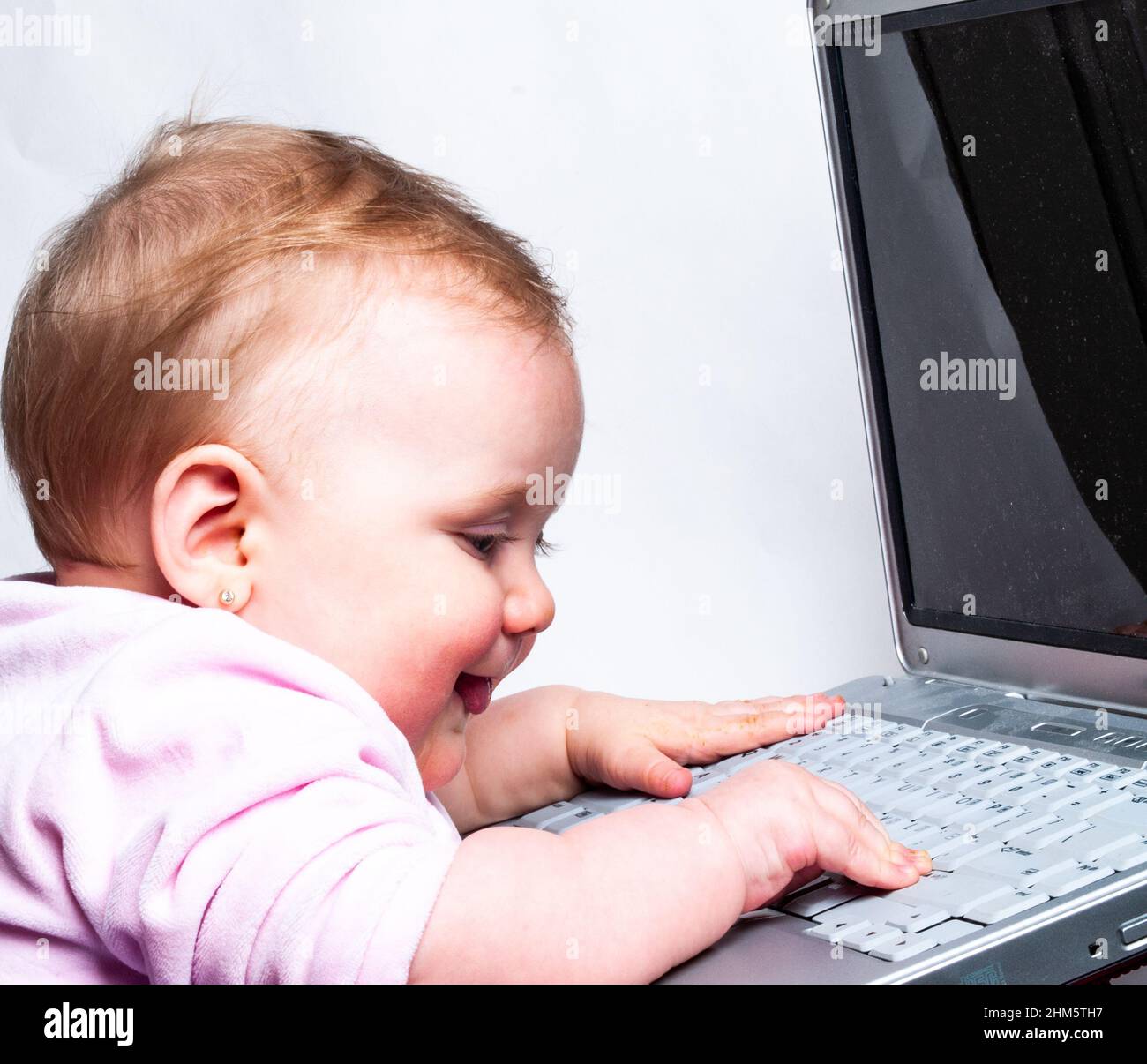 Baby playing on laptop keyboard Stock Photo - Alamy