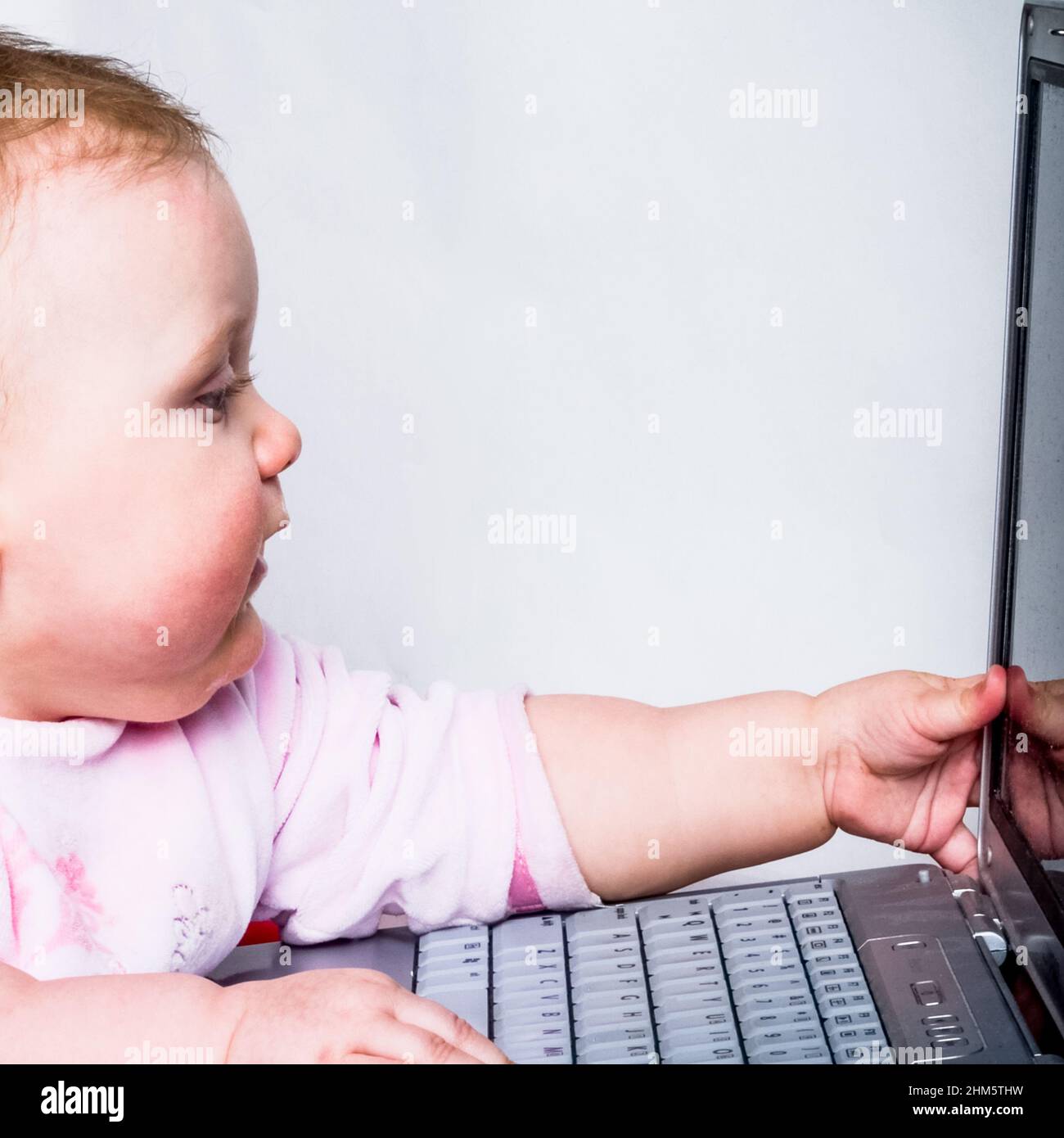 Baby playing on laptop keyboard Stock Photo - Alamy