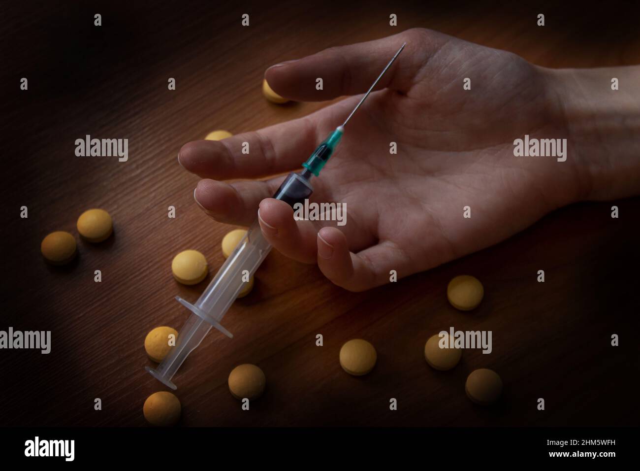 Drug addiction concept. Hand holding drug syringe and pills Stock Photo ...