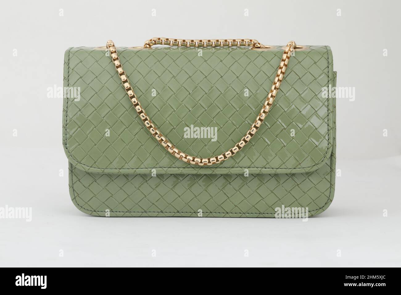 Closeup shot of a fashionable green leather bag with a golden chain ...