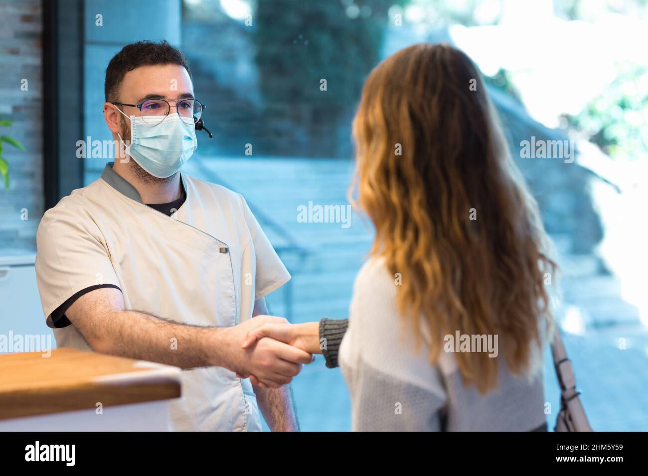 Patient greeting health center receptionist with handshake Stock Photo ...