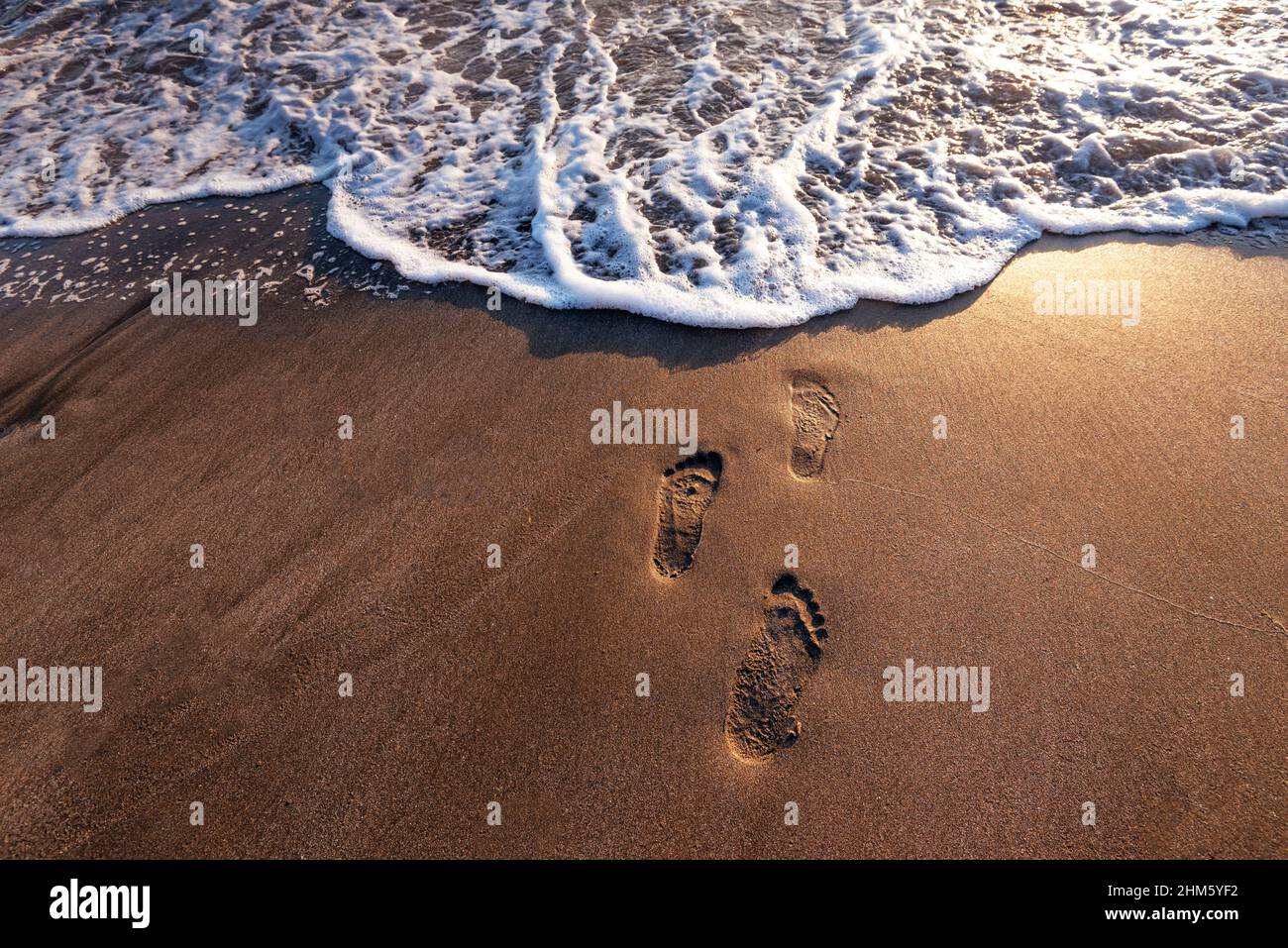 beach, wave and footsteps at sunset time in summer Stock Photo - Alamy
