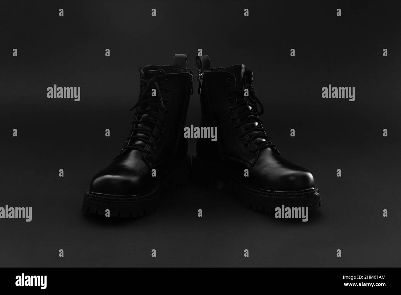 Pair of glittering isolated leather winter autumn unisex black boots on ...