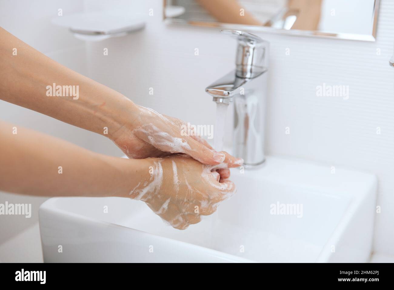 Washing hands under the flowing water tap. Washing hands rubbing with ...