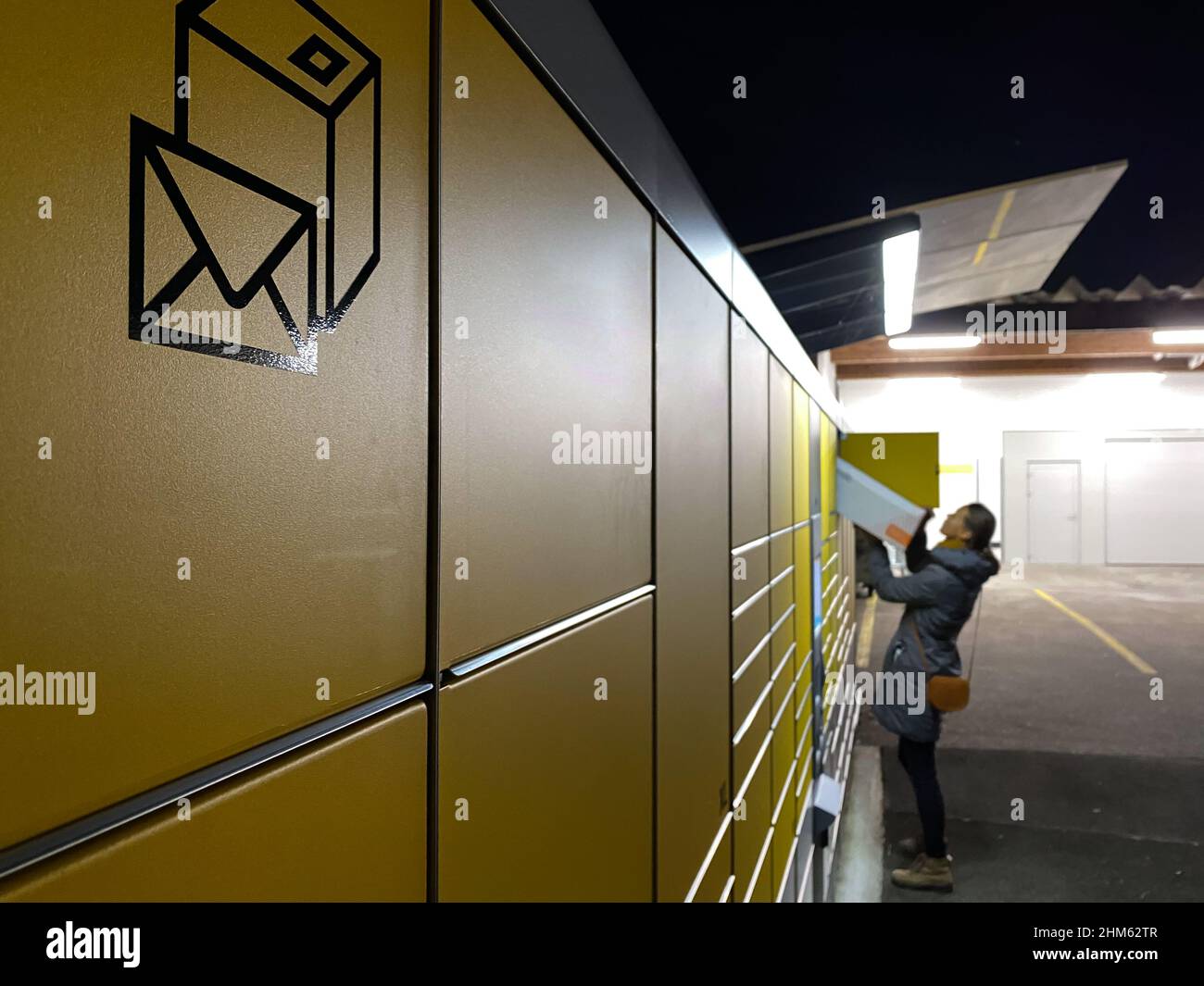 Woman picks up mail from automated self-service post terminal machine ...