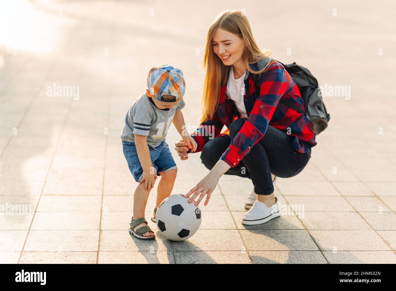 Happy family play football in summer, Mother and son play and run in ...