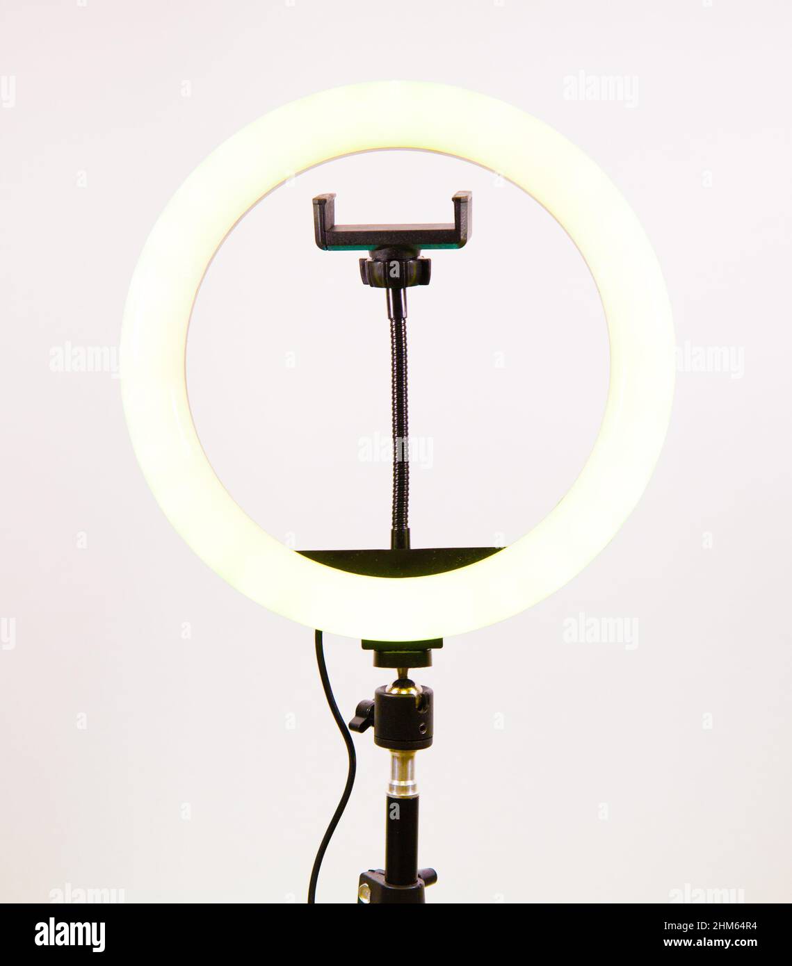 Round lamp with a smartphone holder. Yellow light Stock Photo - Alamy