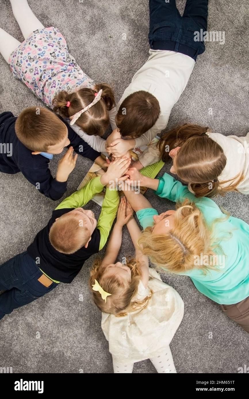 Boys and girls in circle. Happy children having fun. kids lay down ...