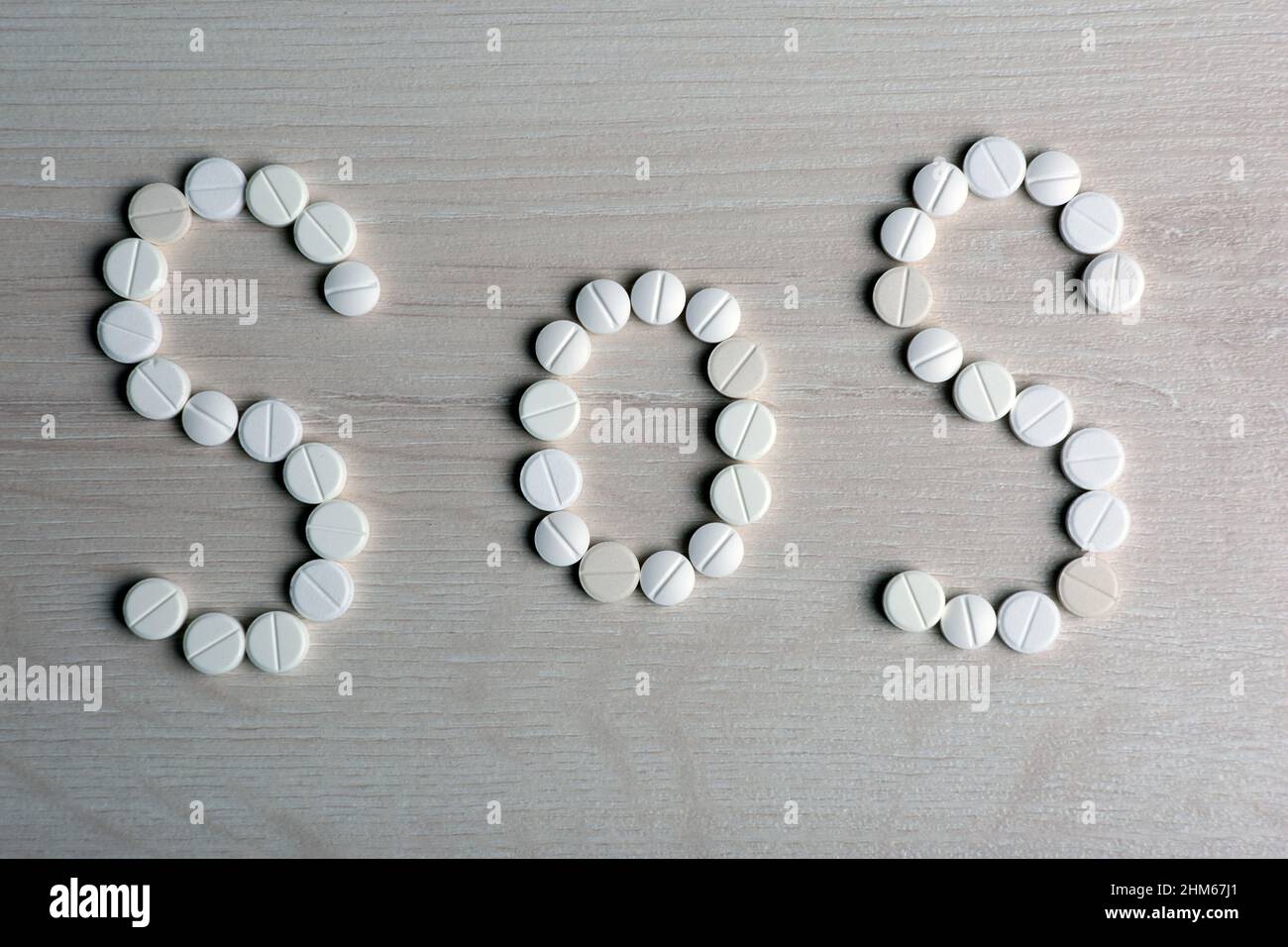 white pills laid out in a word SOS on a table top view Stock Photo - Alamy